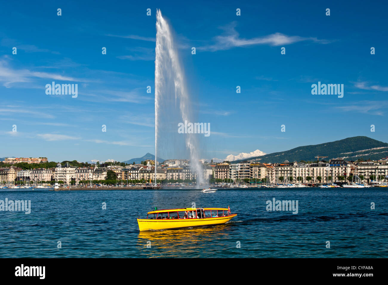Yellow water taxi on Lake Geneva with Jet d'Eau and Mont Blanc mountain range behind, Geneva ...