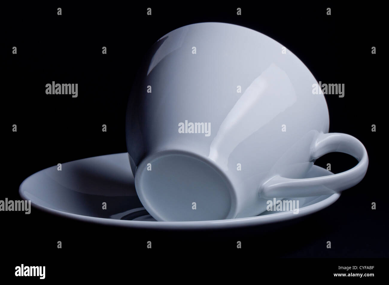 White cup lying on its side on saucer Stock Photo - Alamy