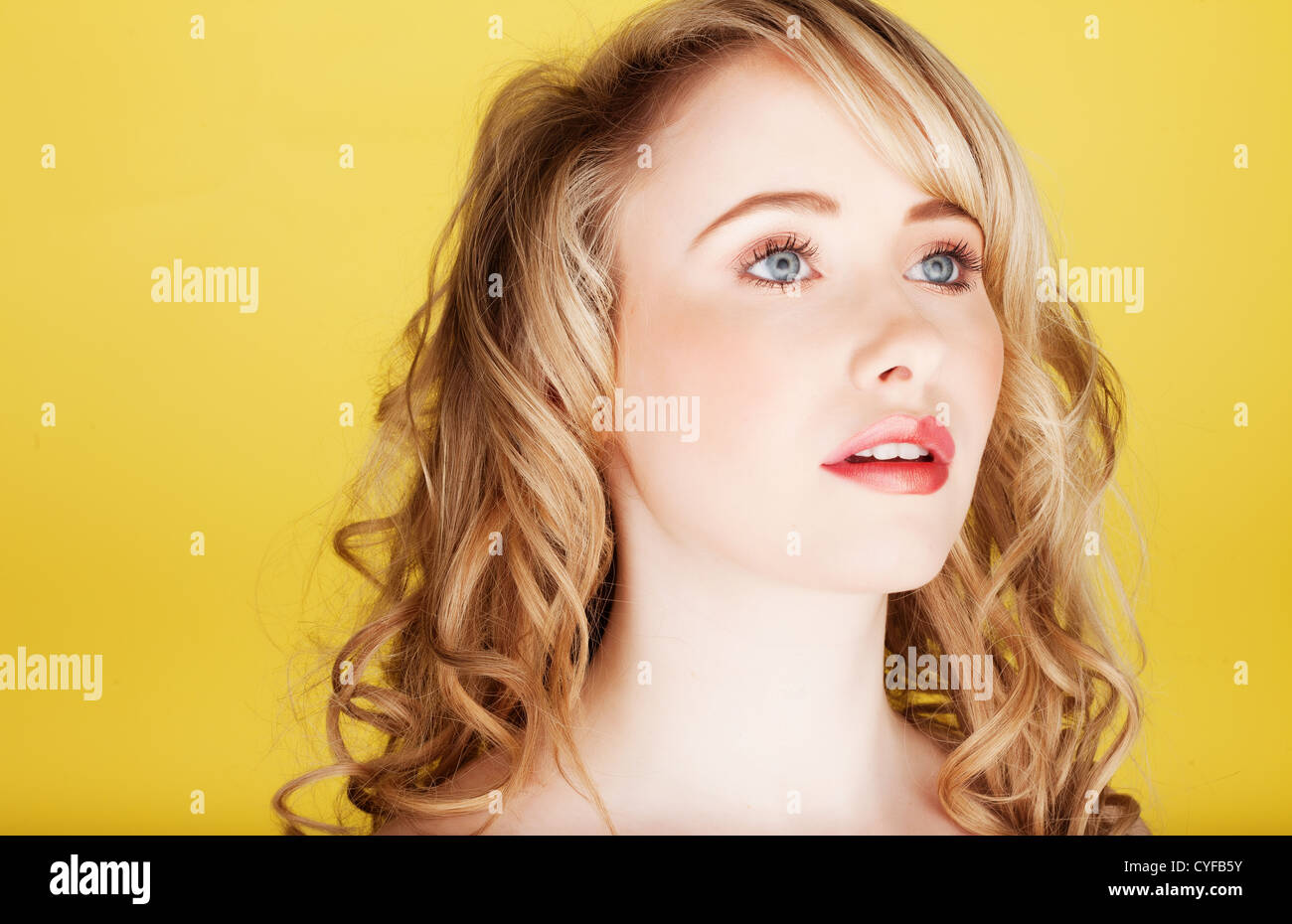 woman with long curly hair, looking away from camera towards the left ...
