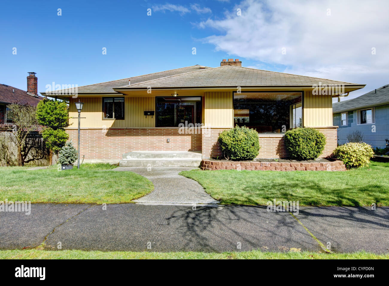 Small American yellow brick rambler house exterior Stock Photo - Alamy