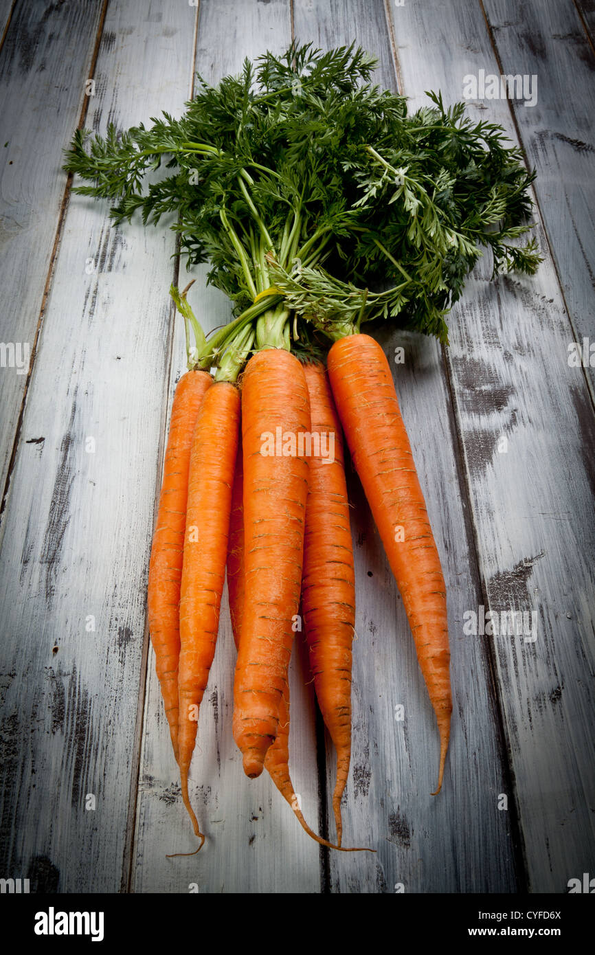 a fresh bunch of carrots on wood background Stock Photo - Alamy