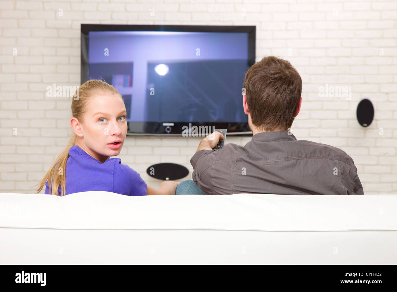 man watching tv woman looking back Stock Photo - Alamy