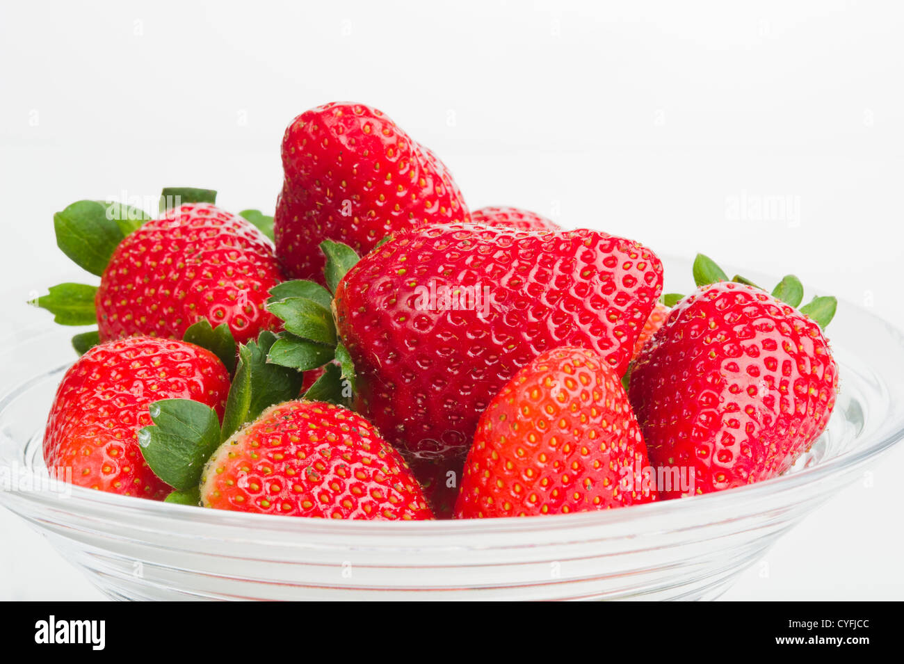 Many strawberries in a plate and white background Stock Photo - Alamy