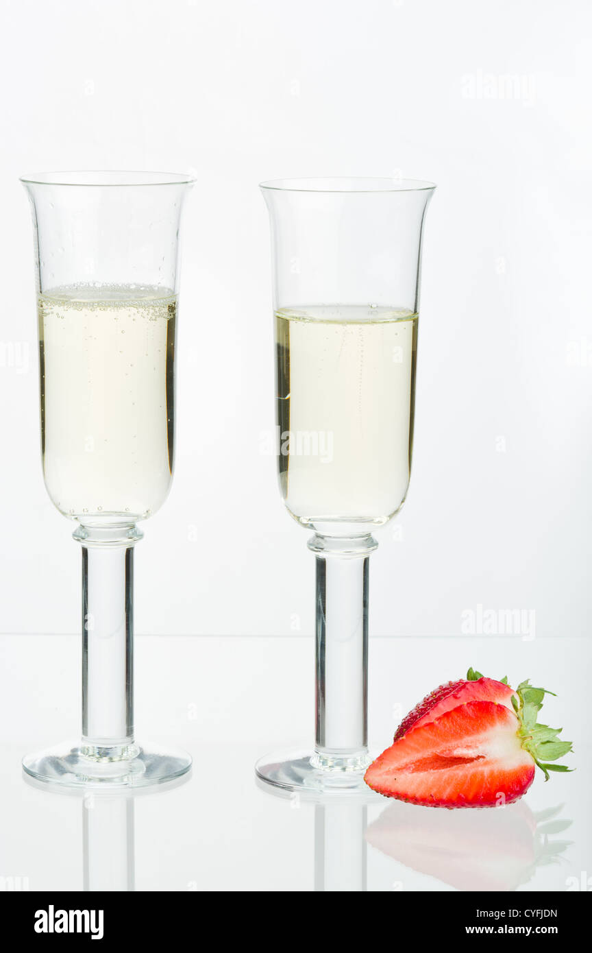 Two fulls sparkling glass, split strawberry, reflection and white ...