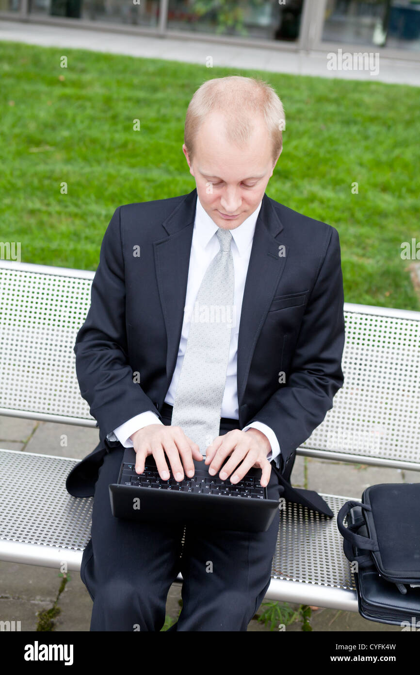 business man sitting outdoor working with notebook in summer Stock ...
