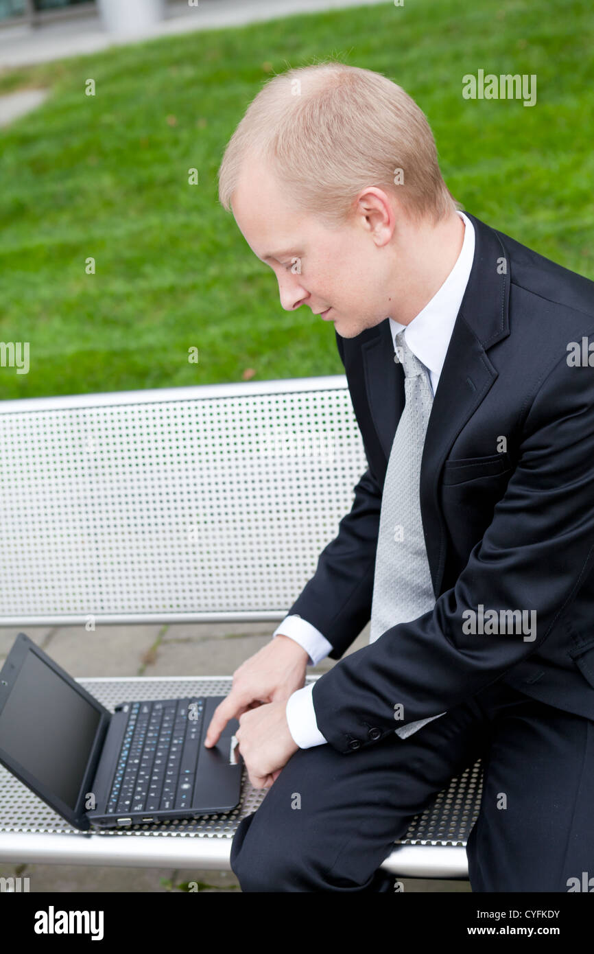 business man sitting outdoor working with notebook in summer Stock ...