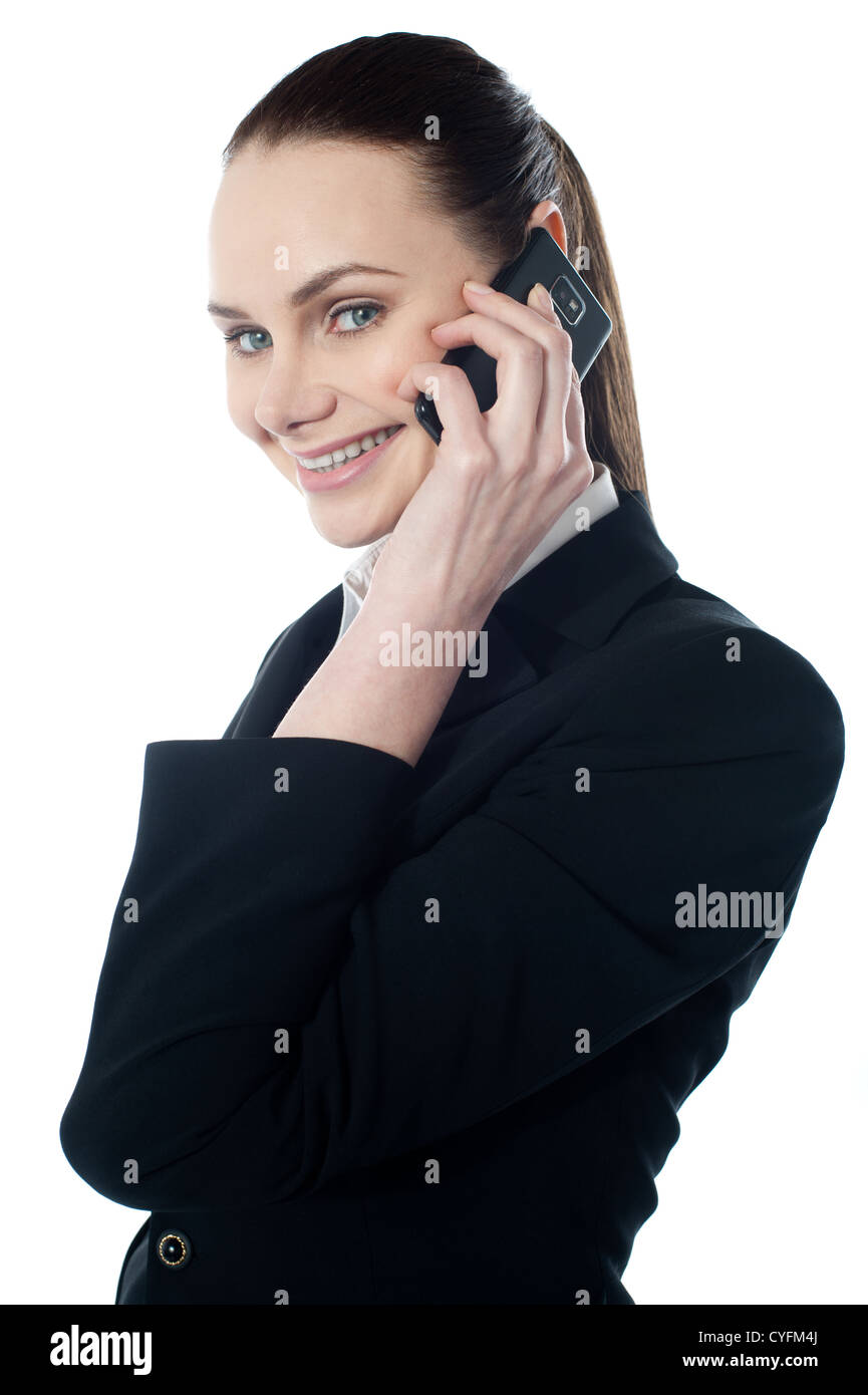 Female executive talking on mobile and smiling at camera Stock Photo ...