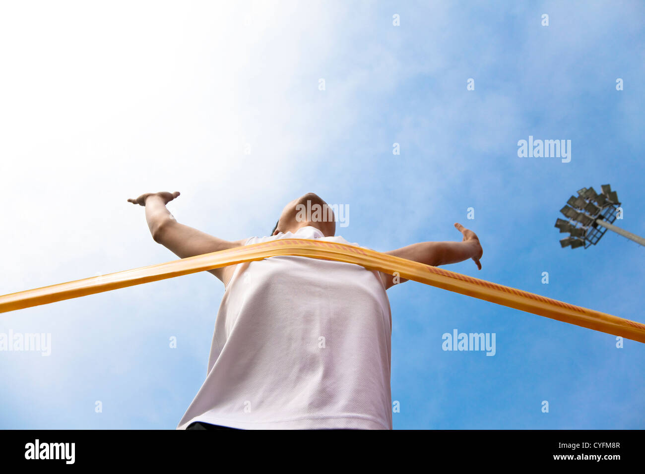 Winning athlete with cloud background Stock Photo - Alamy