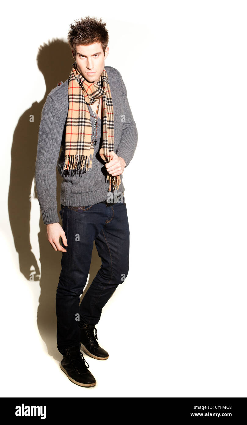 Fashionable tall slim young man with spiky hair wearing scarf, slightly ...