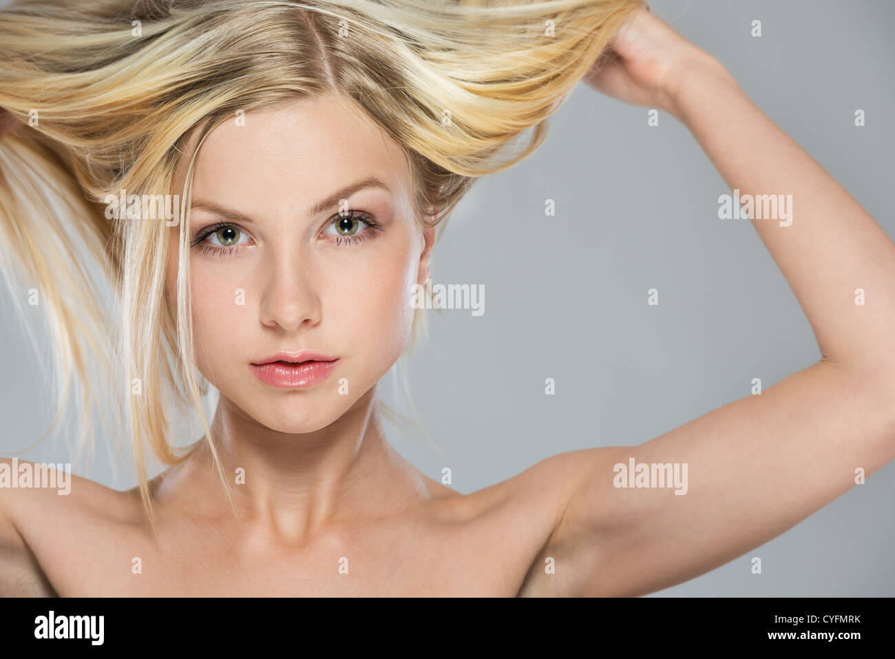 Portrait of blond girl rising up hair Stock Photo - Alamy