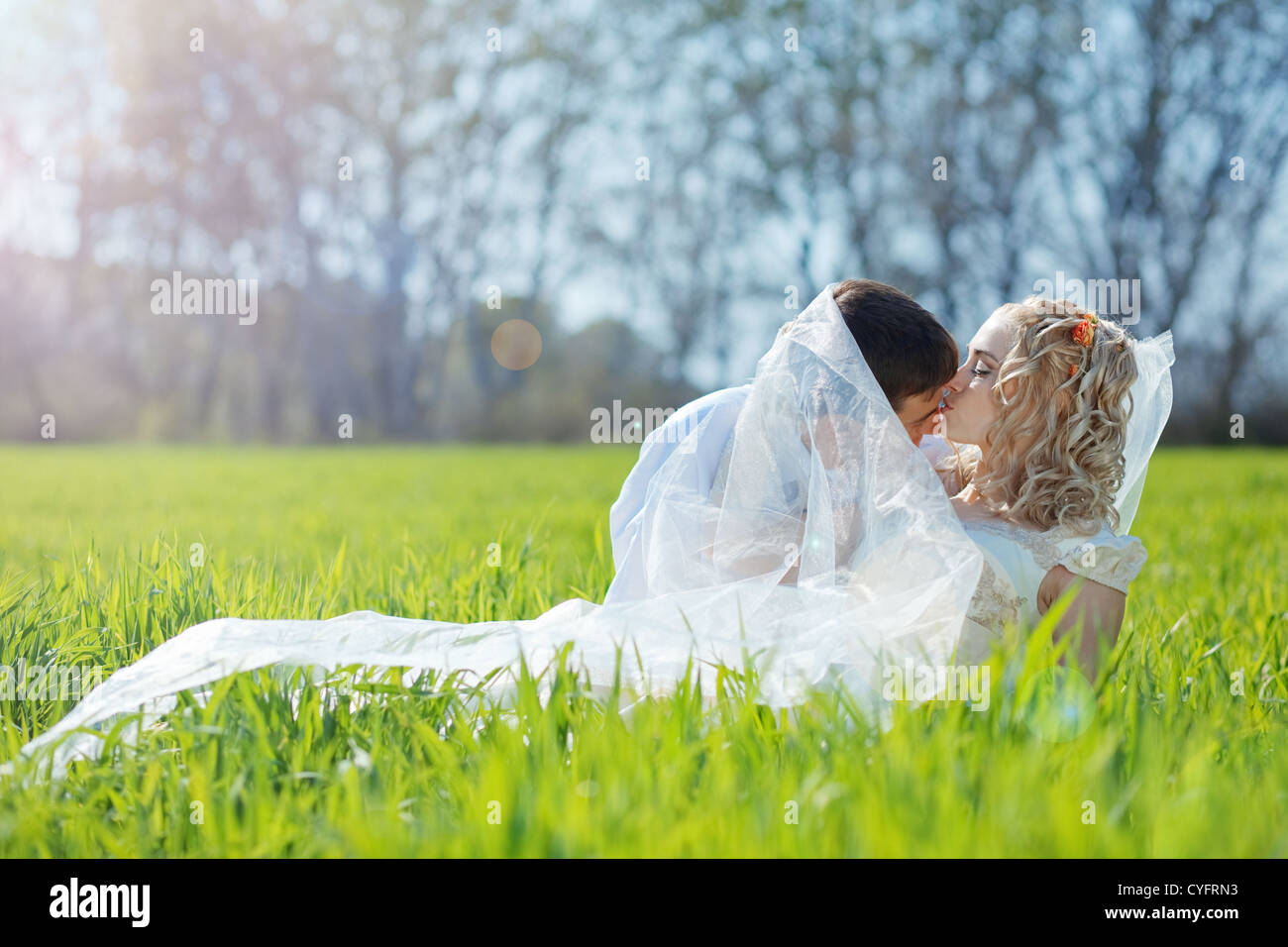 Bride and groom walking at filed on fresh green grass Stock Photo - Alamy