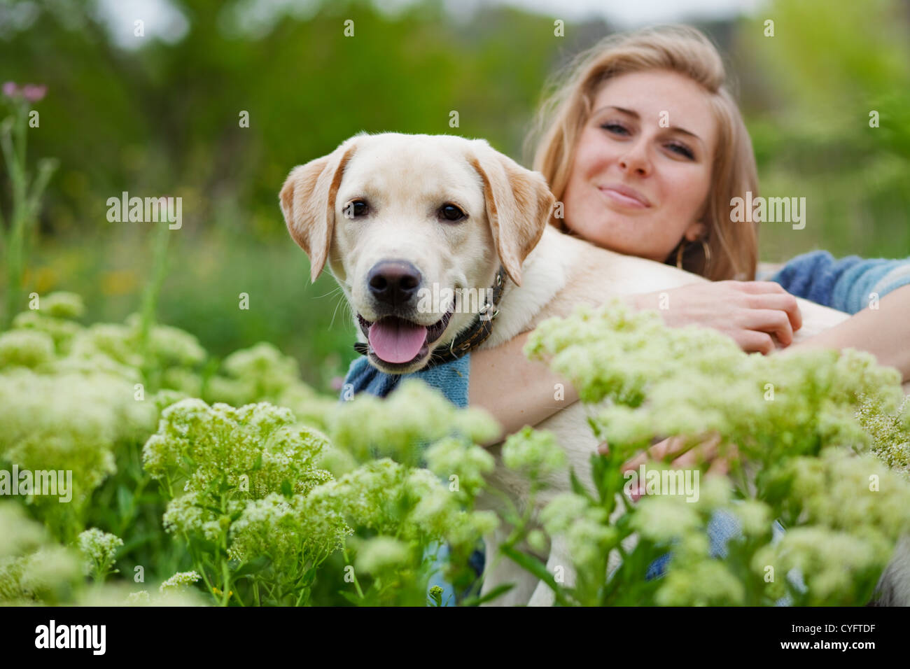 Girl with her dog posing in spring grass Stock Photo - Alamy