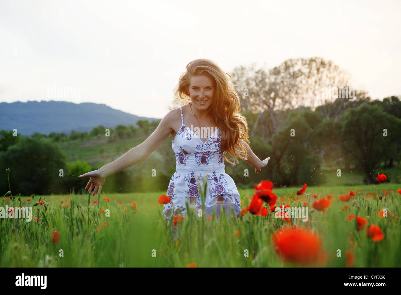 Running girl in poppy field Stock Photo - Alamy