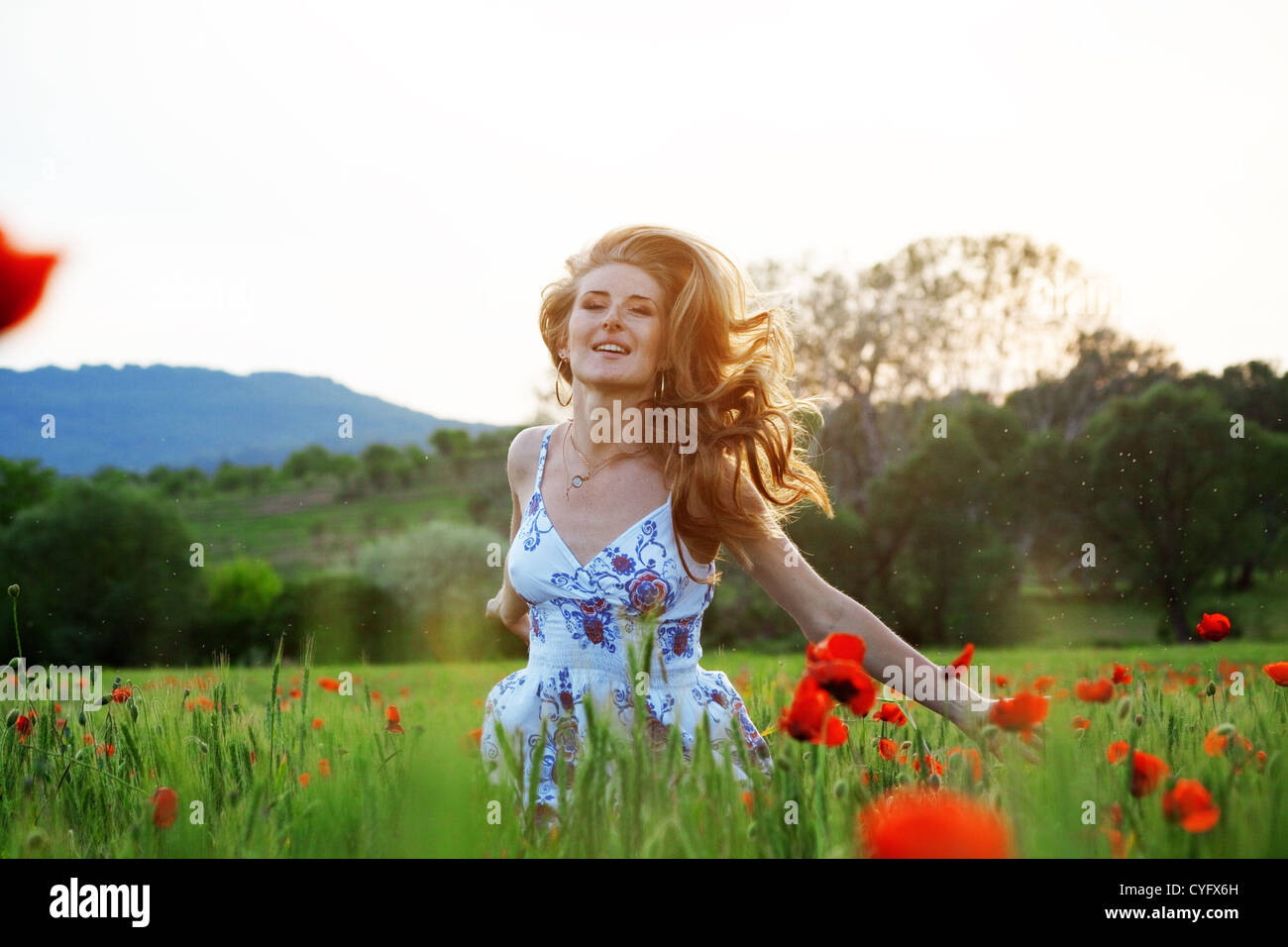 Running girl in poppy field Stock Photo - Alamy