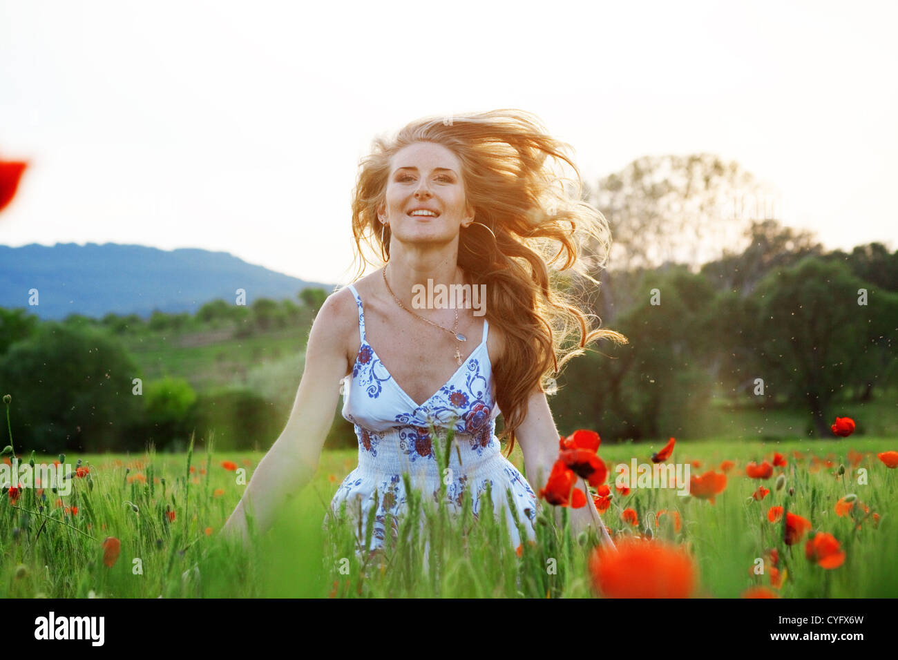 Running girl in poppy field Stock Photo - Alamy