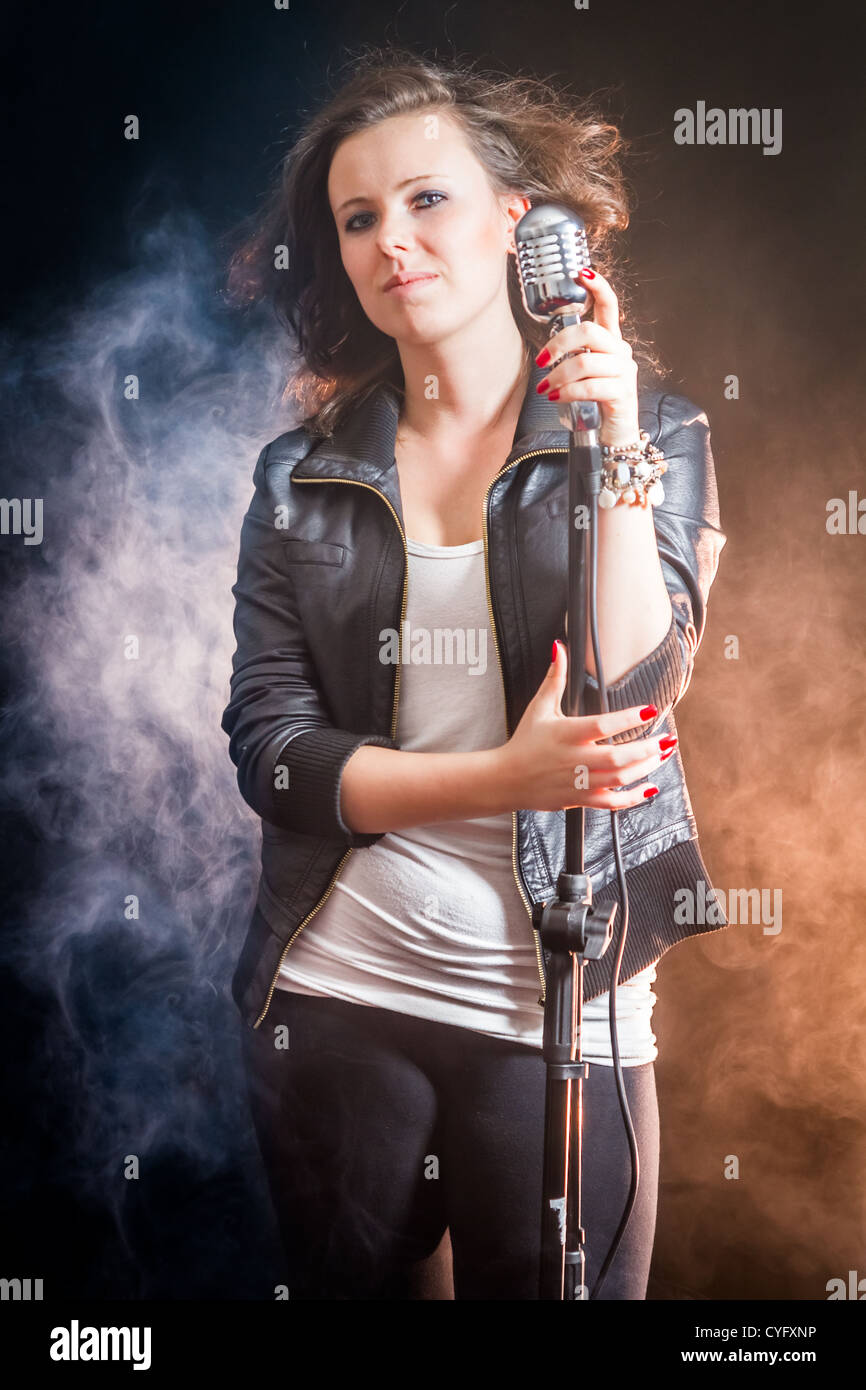 Woman with microphone on the stage Stock Photo - Alamy