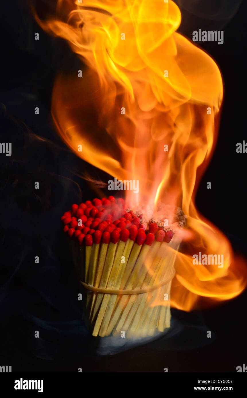 A bundle of matches alight on a black background Stock Photo - Alamy