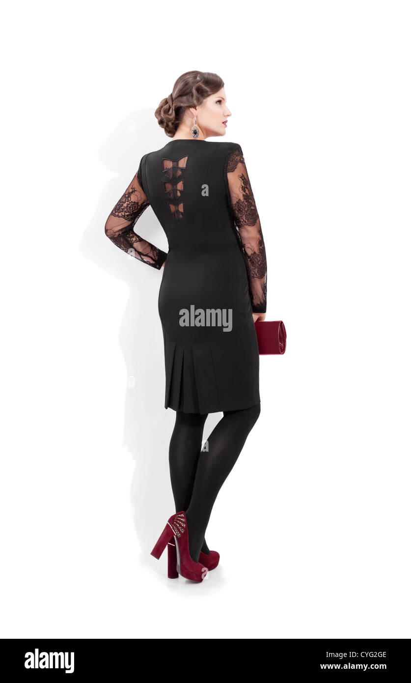 Beautiful model in dark dress standing next to white background Stock ...