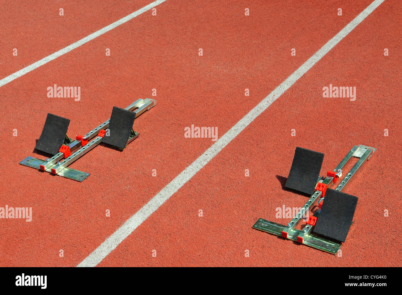 Starting blocks on red running track Stock Photo - Alamy