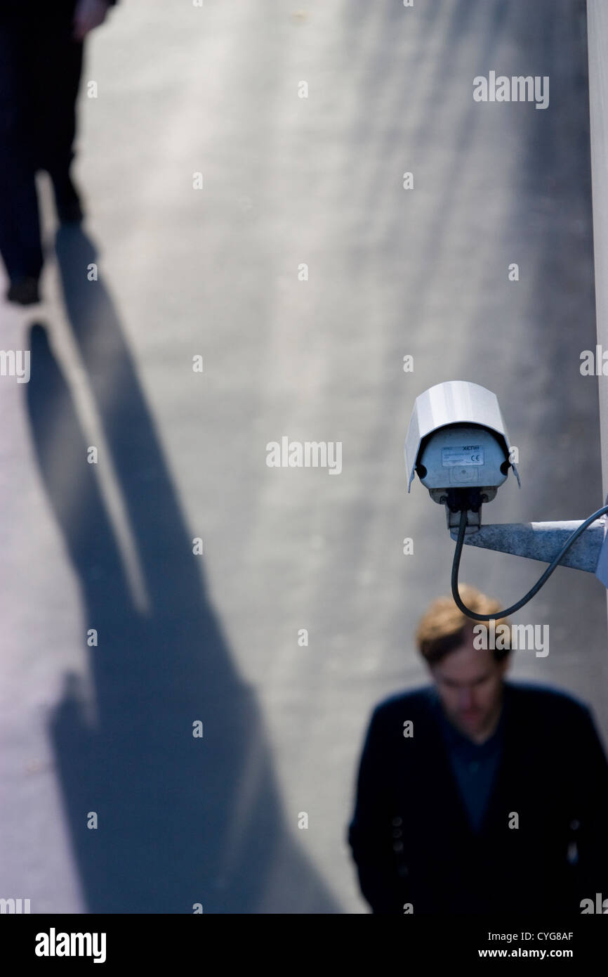 A surveillance CCTV camera watches over a passing commuter, their ...