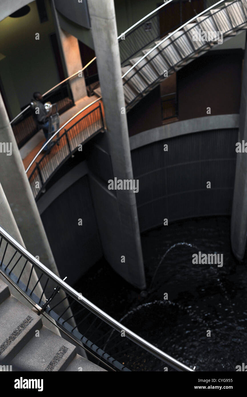 A man viewed from above walking up a stairway inside a building Stock ...