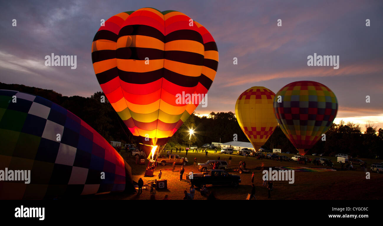 A number of Hot Air Balloons fire their burners lighting up the entire ...