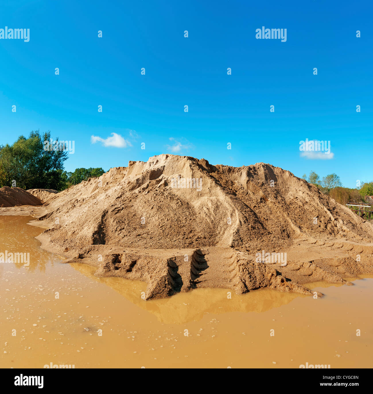 Sand dunes and muddy water under blue sky Stock Photo - Alamy