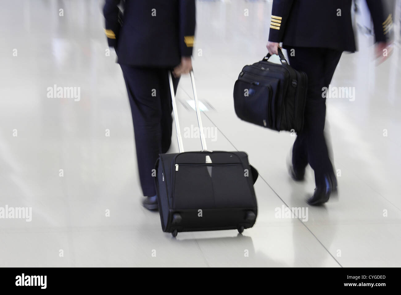 Two pilots walking at the airport Stock Photo - Alamy