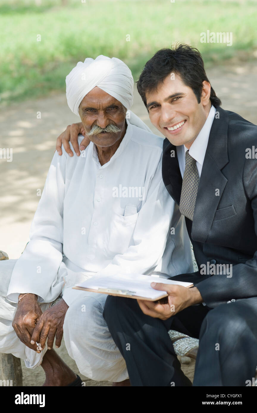 Financial advisor sitting with a farmer and smiling Stock Photo - Alamy
