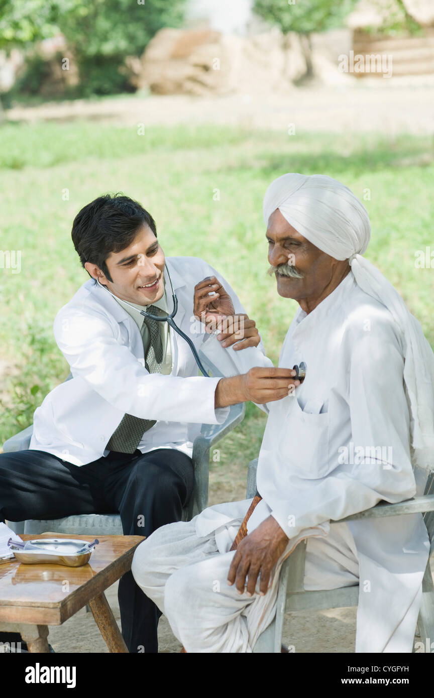 Doctor examining a farmer with a stethoscope Stock Photo - Alamy
