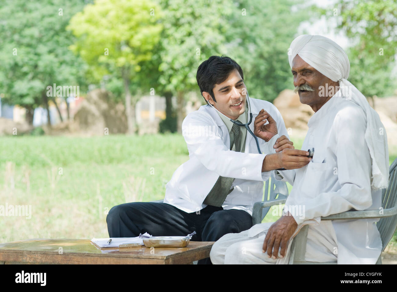 Doctor examining a farmer with a stethoscope Stock Photo - Alamy