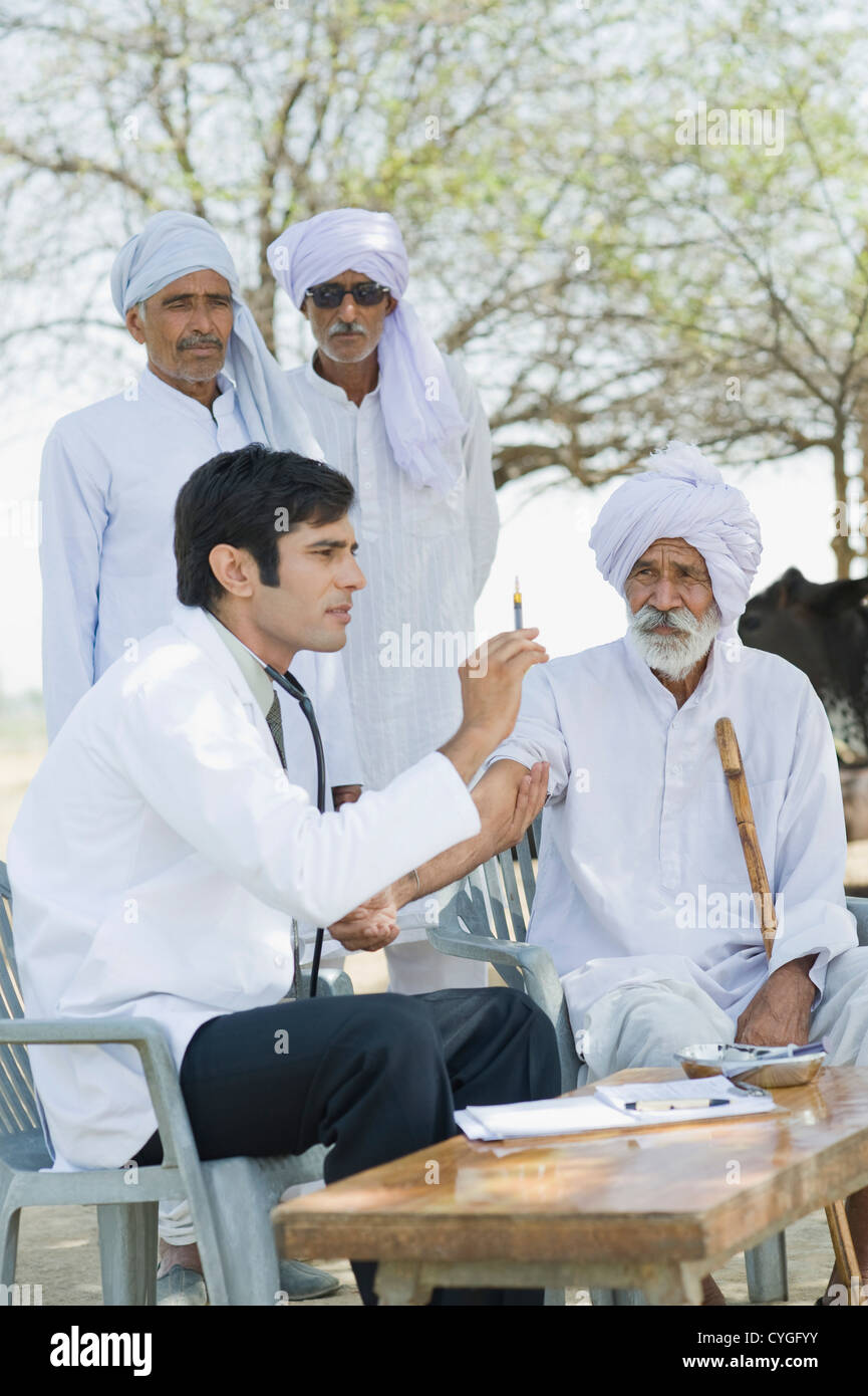 Doctor injecting farmer's arm Stock Photo - Alamy
