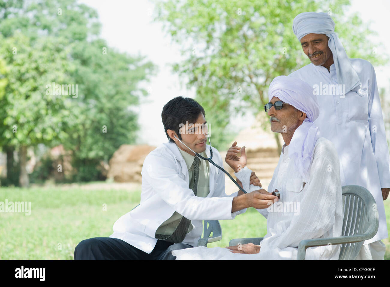 Doctor examining a farmer with a stethoscope Stock Photo - Alamy