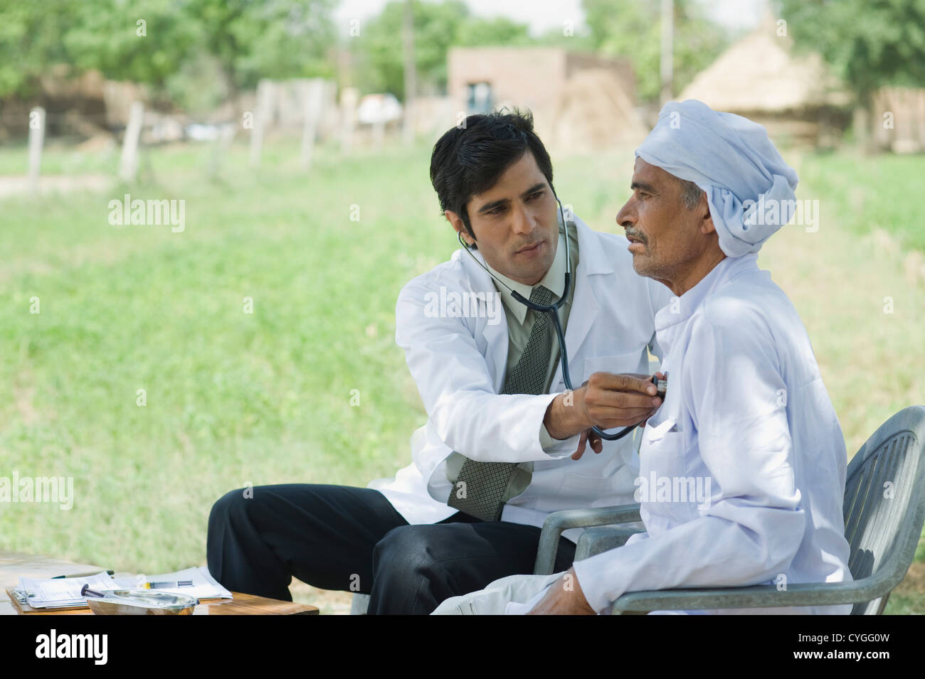 Doctor examining a farmer with a stethoscope Stock Photo - Alamy