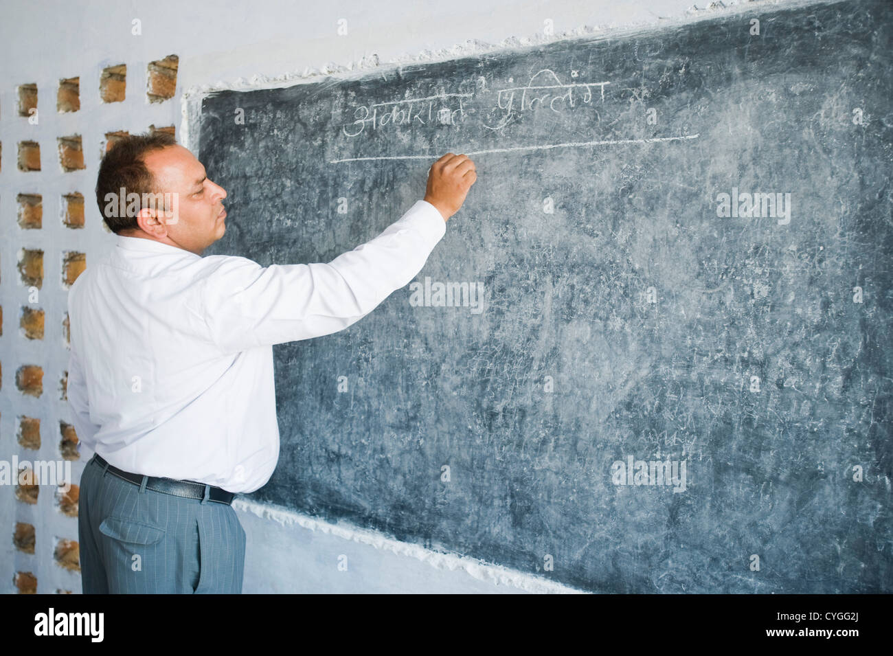 Teacher writing on a blackboard Stock Photo - Alamy