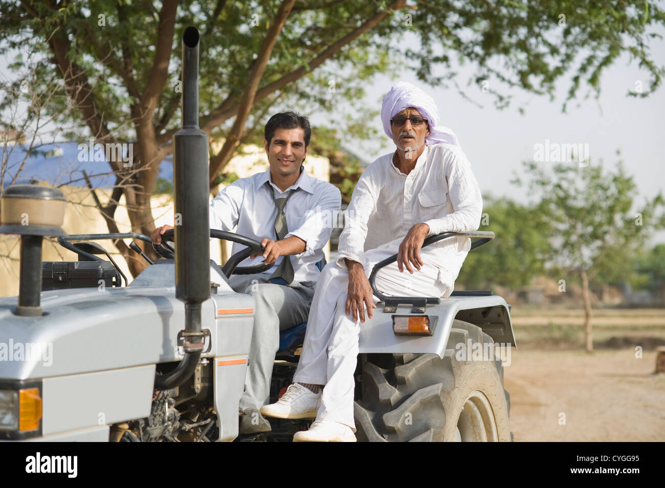 Farmer sitting on a tractor with his son Stock Photo - Alamy