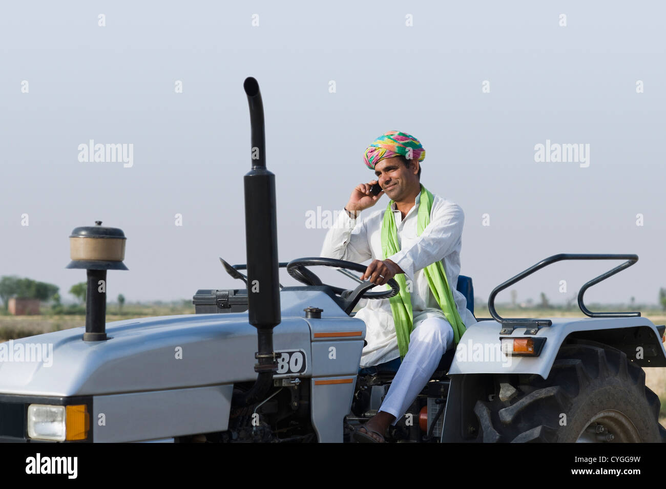 Farmer talking on a mobile phone while driving a tractor Stock Photo ...