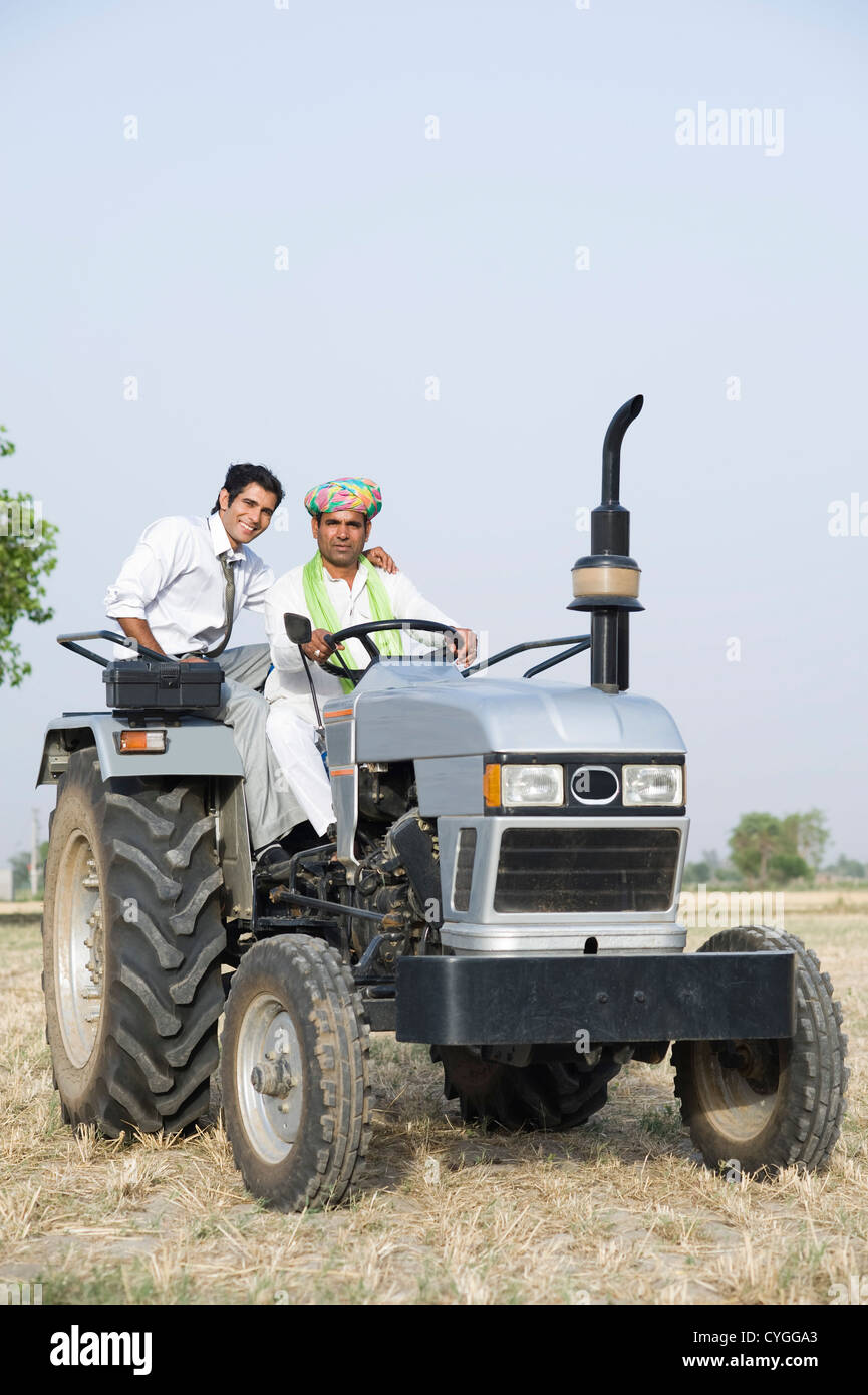 Financial advisor sitting on a tractor with a farmer Stock Photo - Alamy