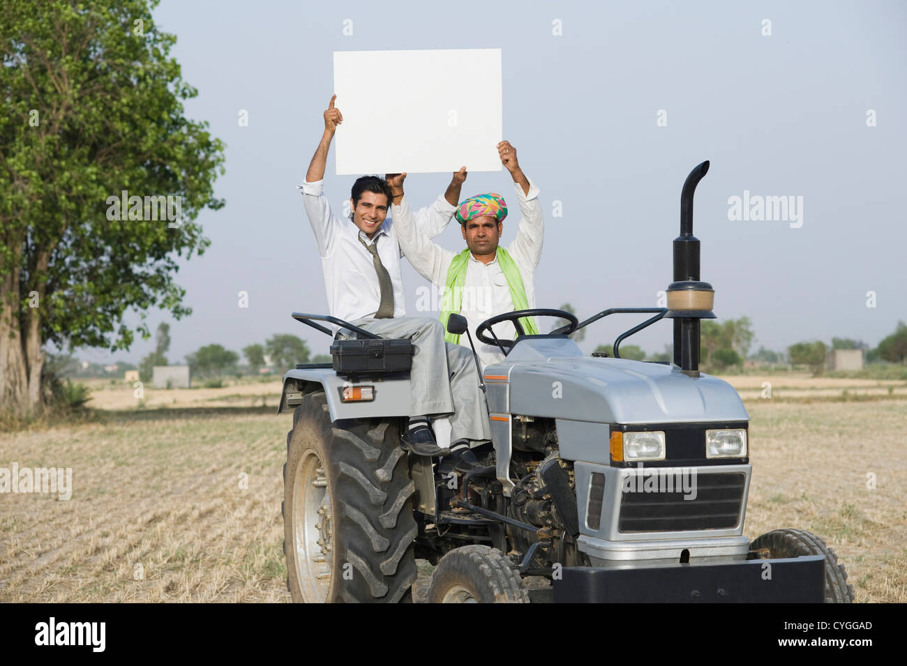 Financial advisor and a farmer showing a placard on a tractor Stock ...
