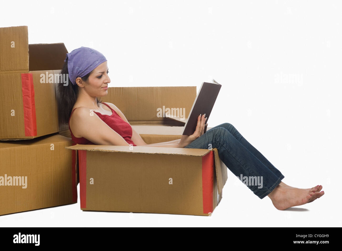 Woman reading a book in a cardboard box Stock Photo - Alamy