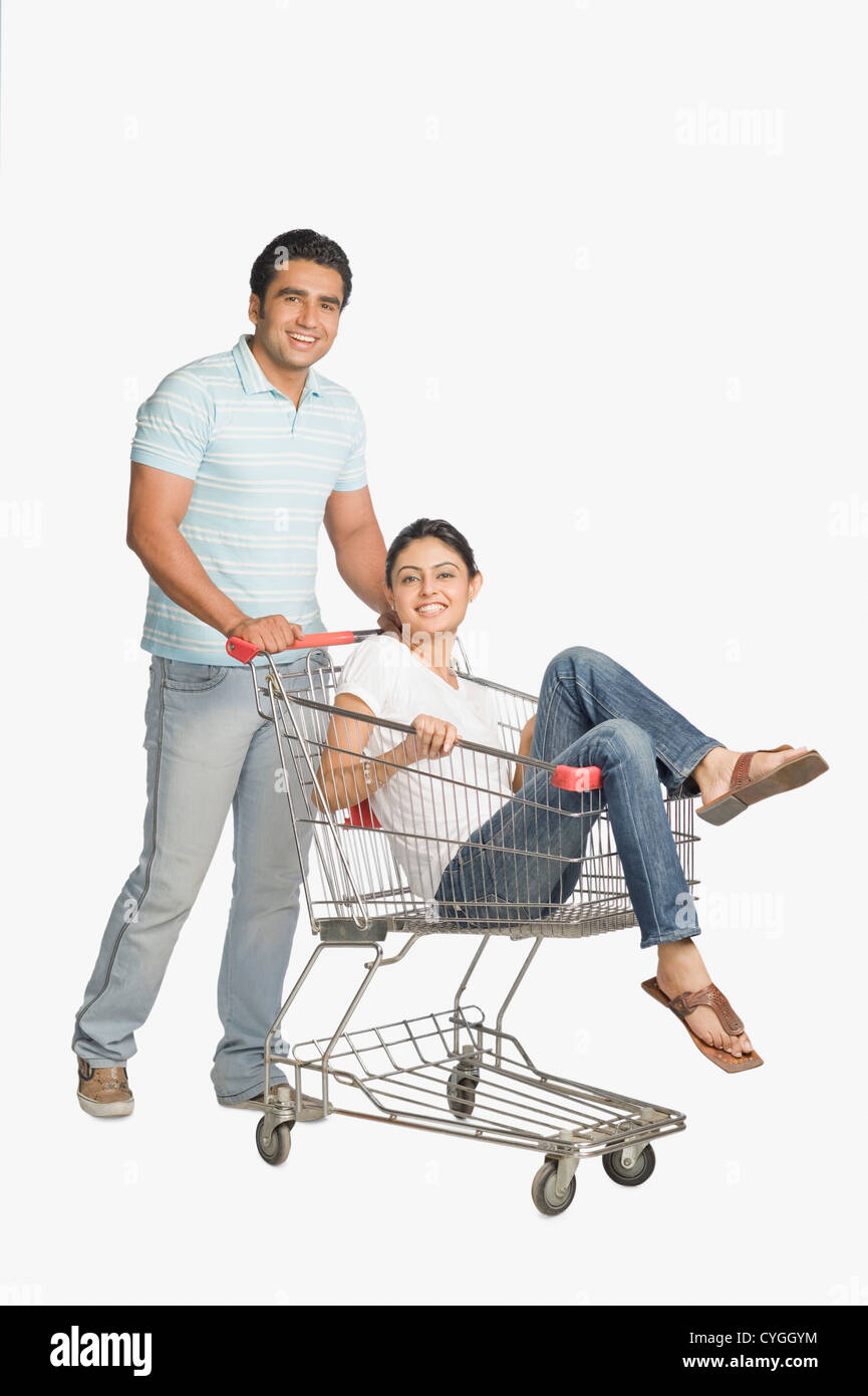 Man pushing a woman sitting in shopping cart Stock Photo - Alamy