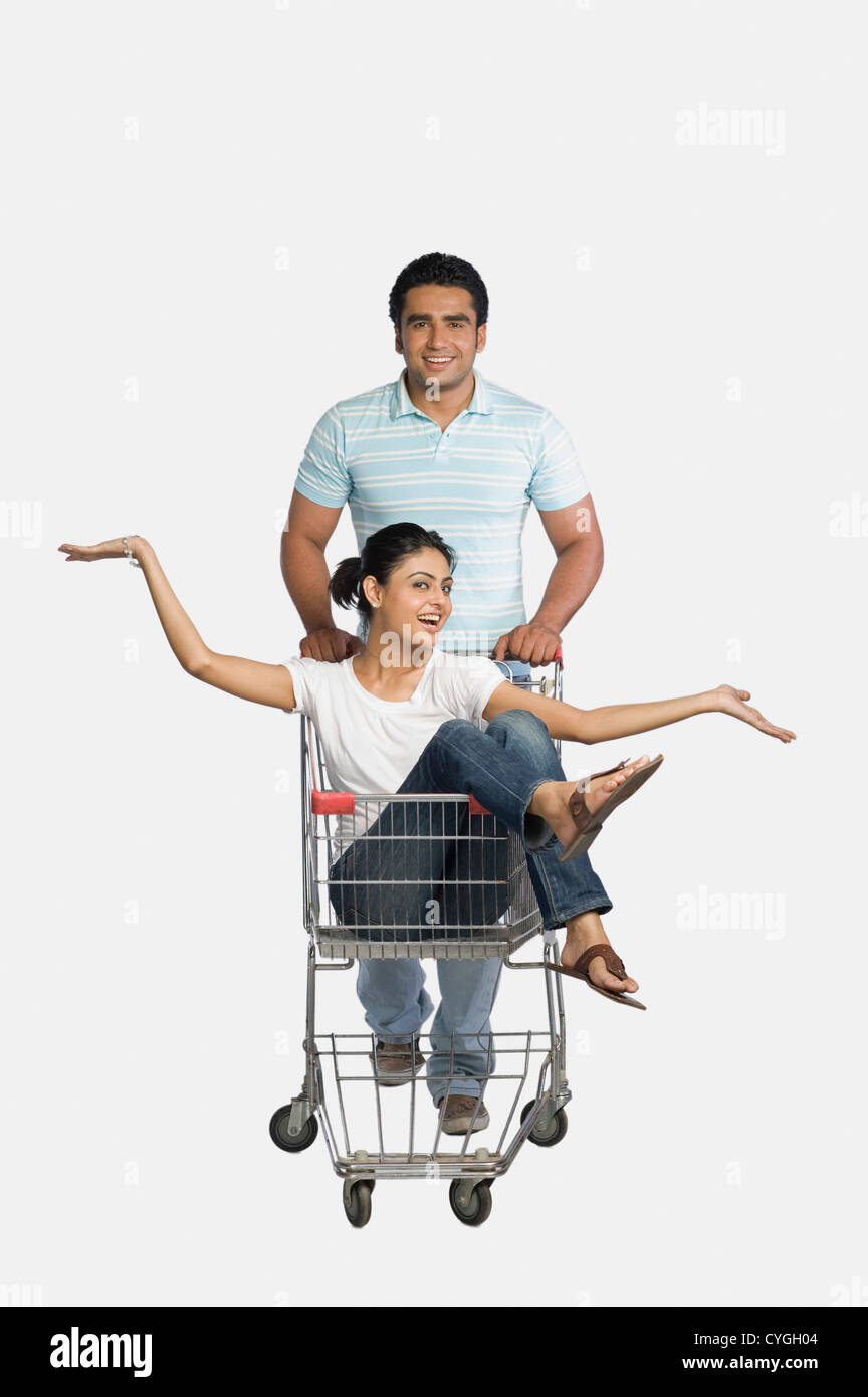 Man pushing a woman sitting in shopping cart Stock Photo - Alamy