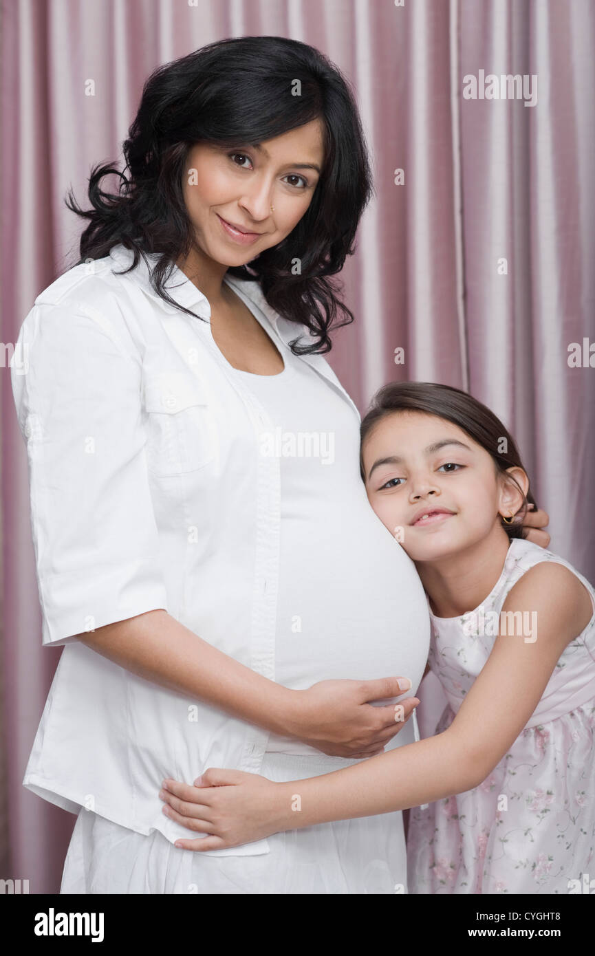 Girl hugging her pregnant mother Stock Photo - Alamy