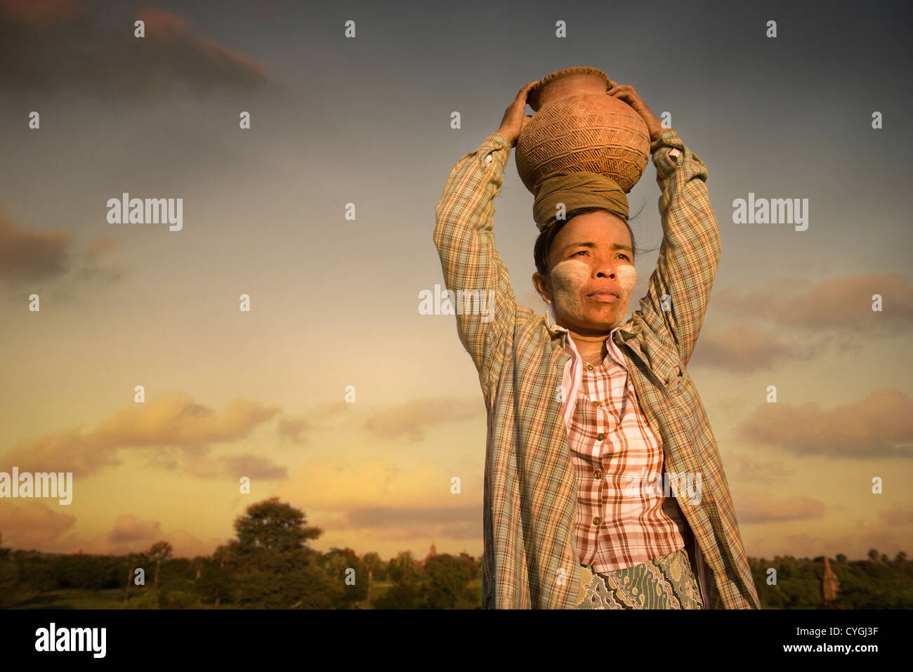 traditional myanmar farmer carrying pot on her head during sunset Stock ...