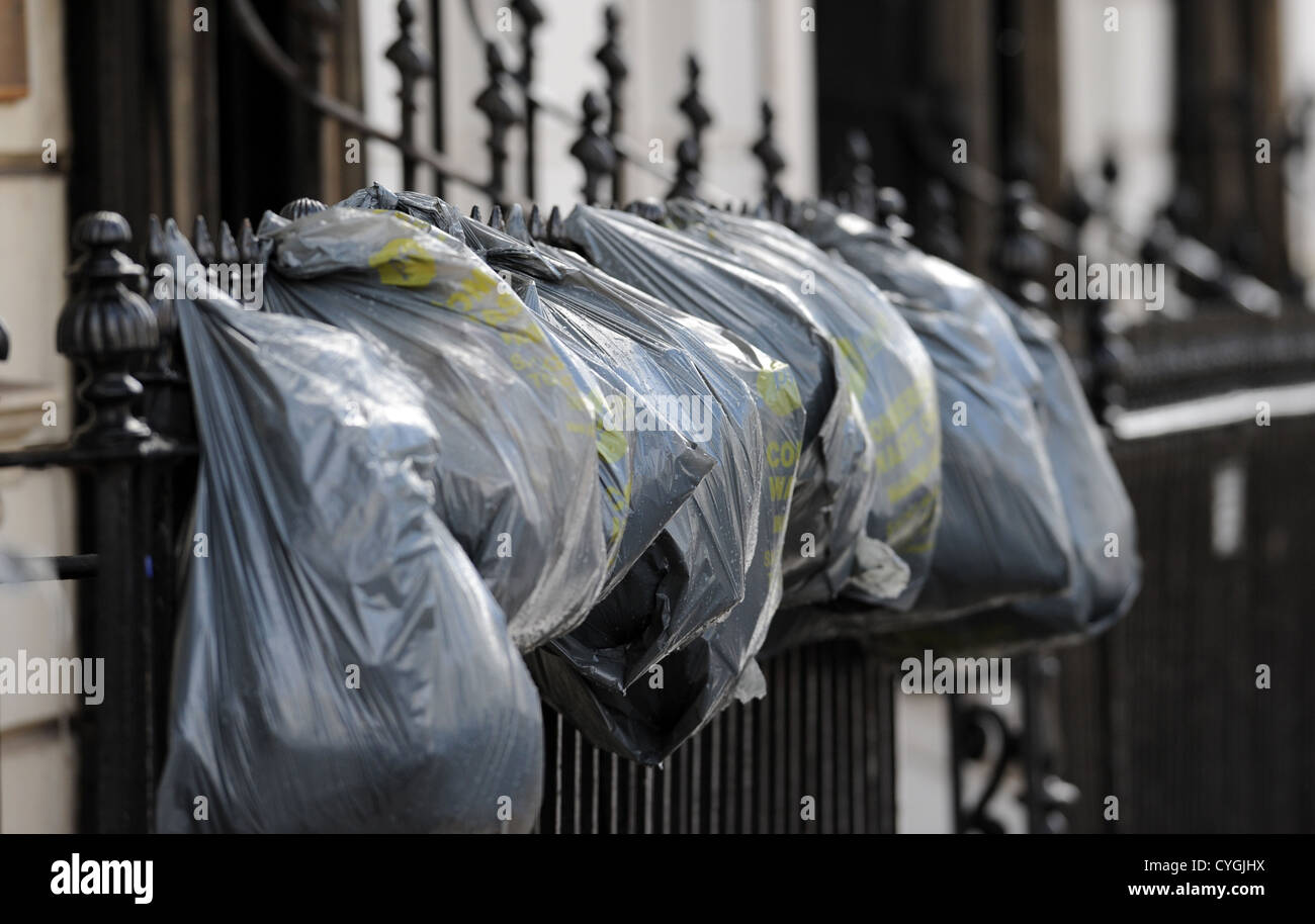Commercial Waste Only rubbish bags hanging on iron railings fence in ...