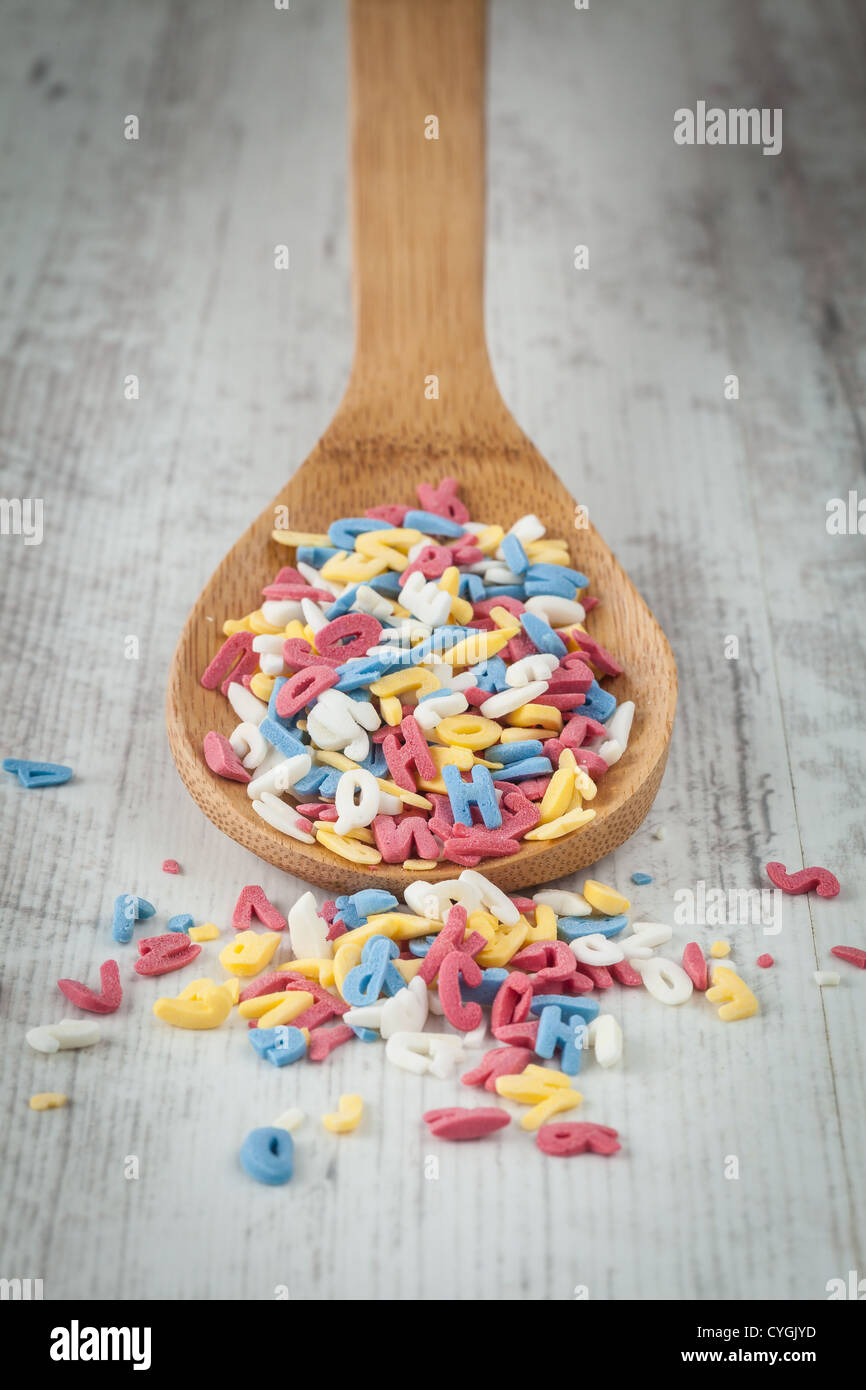 Mini colorful alphabet sugar on wooden spoon Stock Photo - Alamy