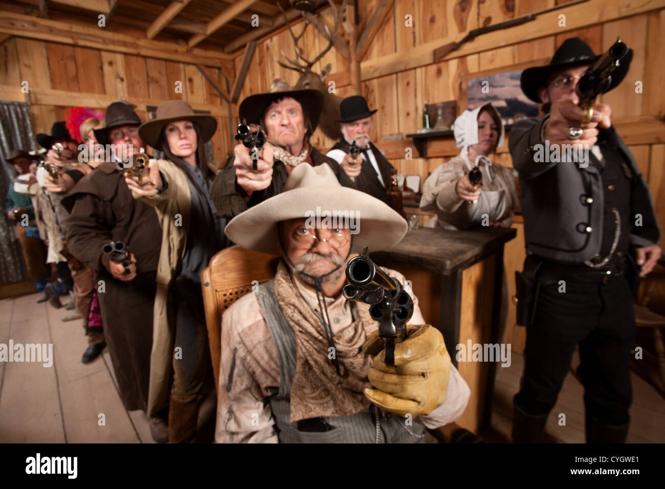 Tough group saloon customers aim their weapons straight ahead. Focus is ...