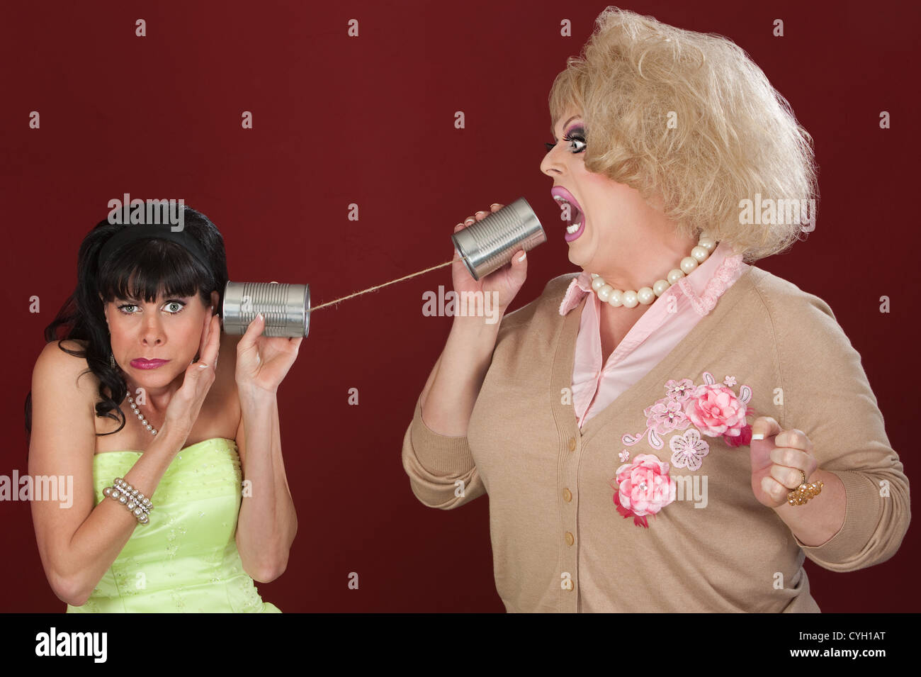 Woman with friend in drag talk through tin cans Stock Photo - Alamy