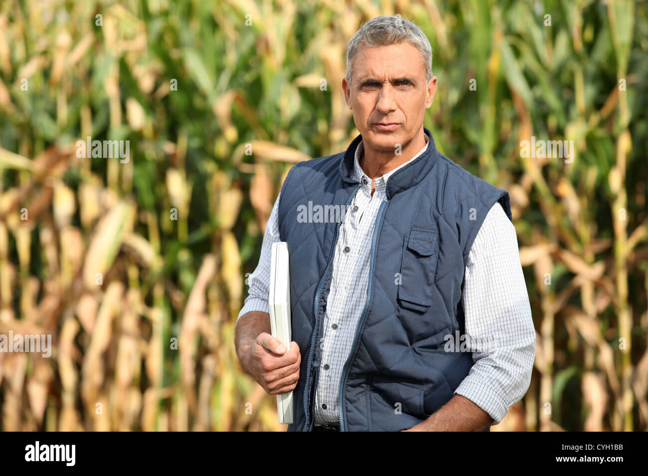 Experienced farmer standing in his field Stock Photo - Alamy