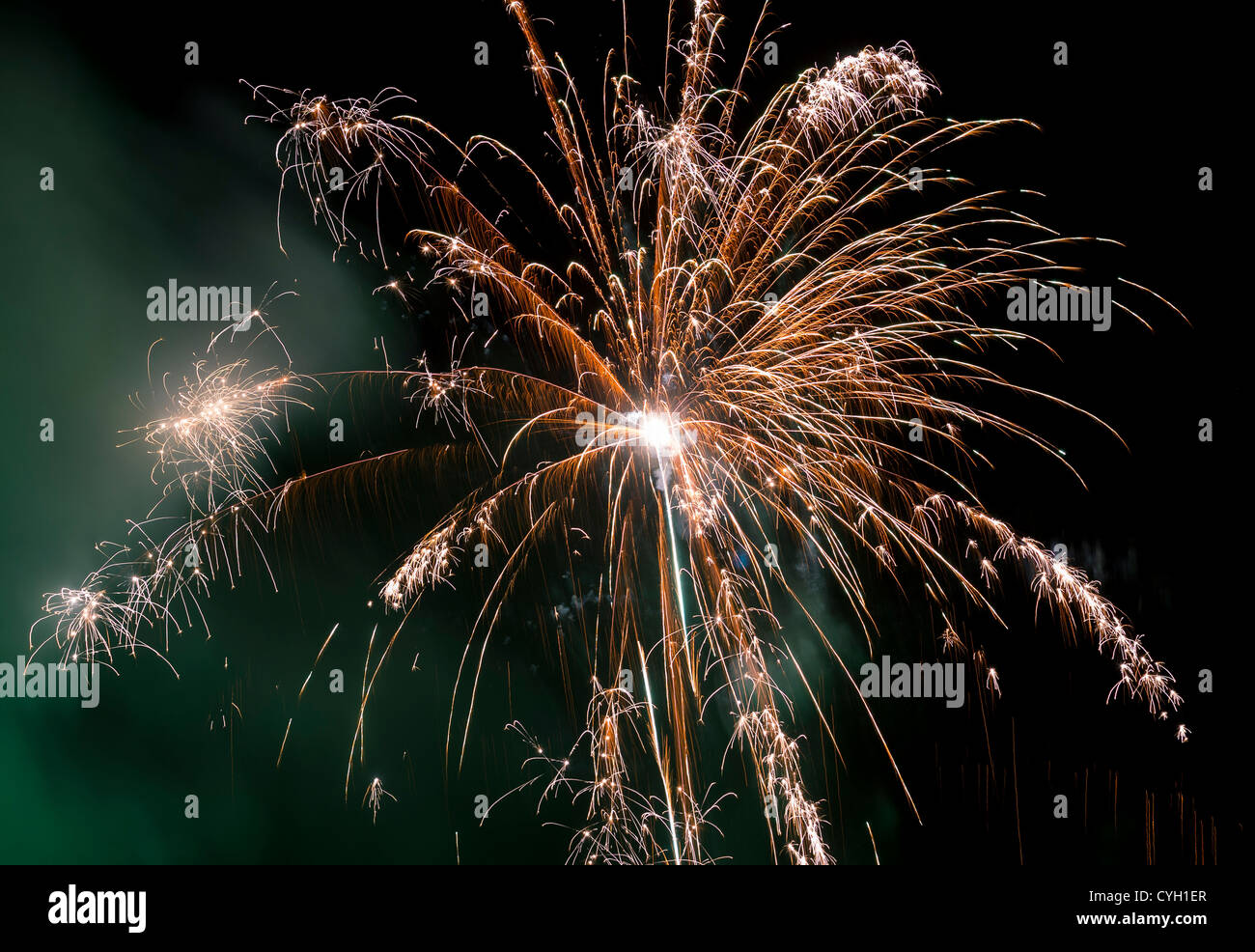An exploding firework with orange streamers and white sparks Stock ...
